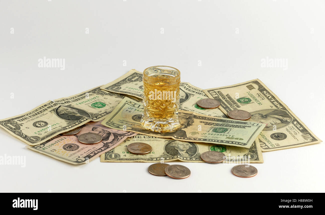 Glass of alcohol drink with money isolated on white background Stock ...