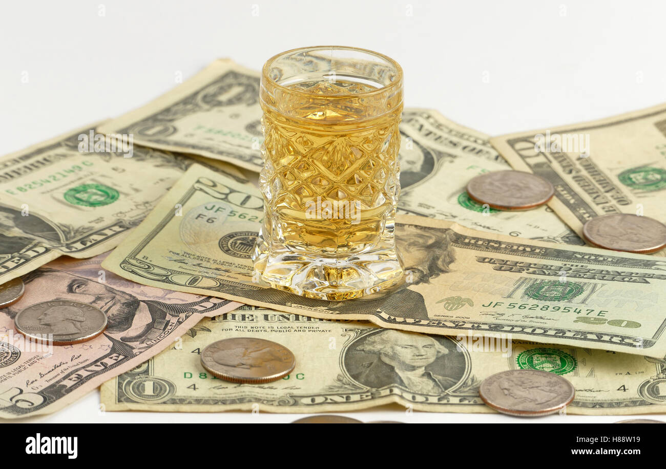 Glass of alcohol drink with money isolated on white background Stock ...