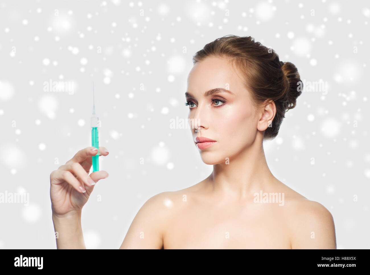 woman holding syringe with injection over snow Stock Photo - Alamy