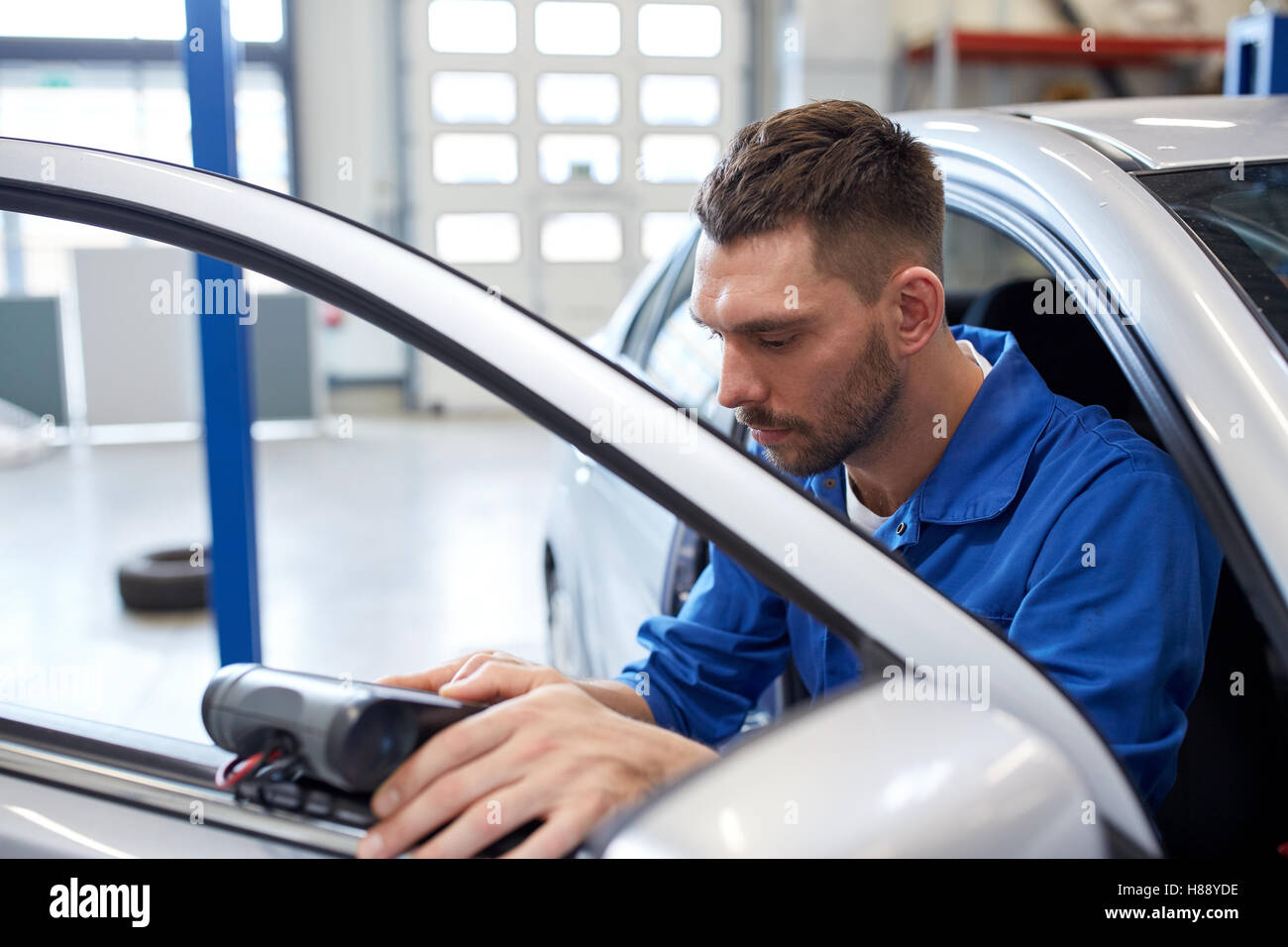 mechanic man with diagnostic scanner at car shop Stock Photo - Alamy