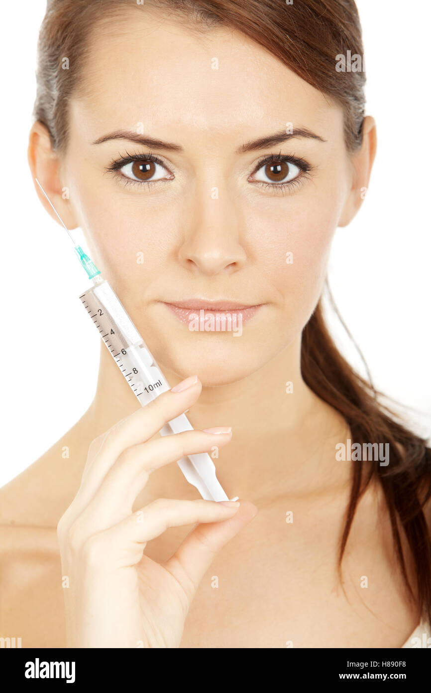 Young brunette woman holding syringe Stock Photo - Alamy