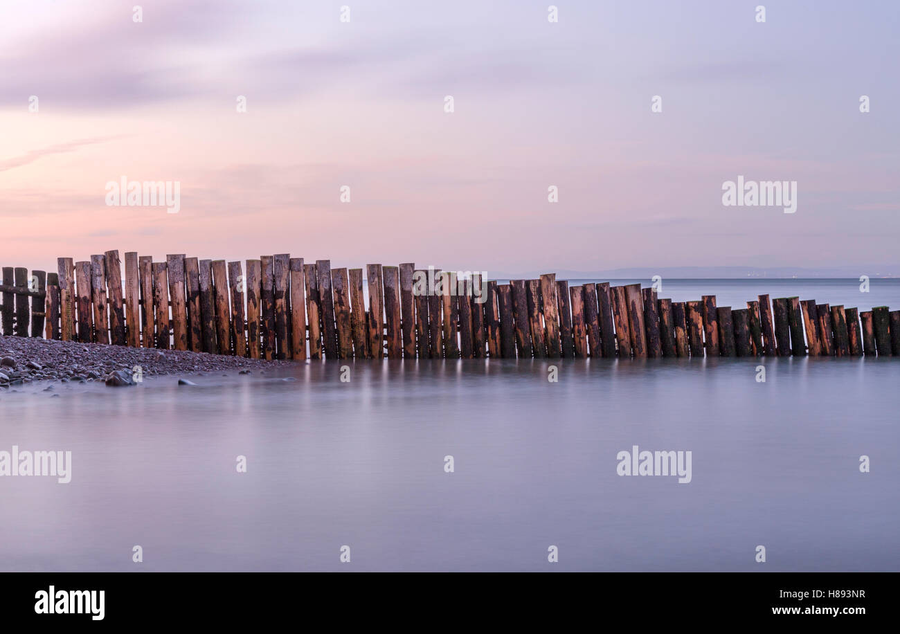 Sunset over Porlock Weir's timber groyne sea defences, Somerset ...
