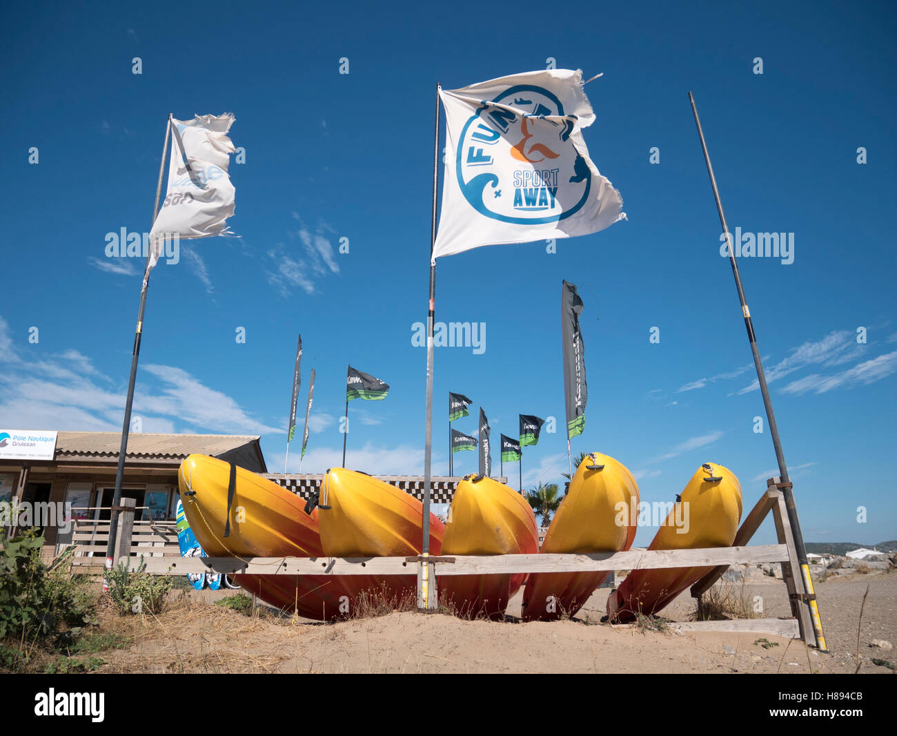 Bright yellow sail boards against a bright blue clear sky at the ...