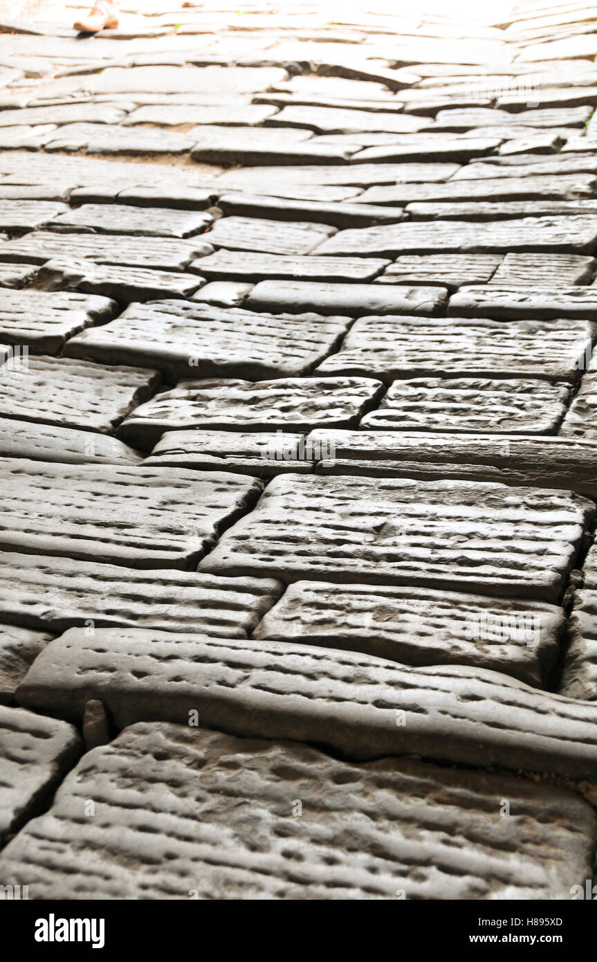 Ancient medieval street paved with cobblestones with carvings to ...