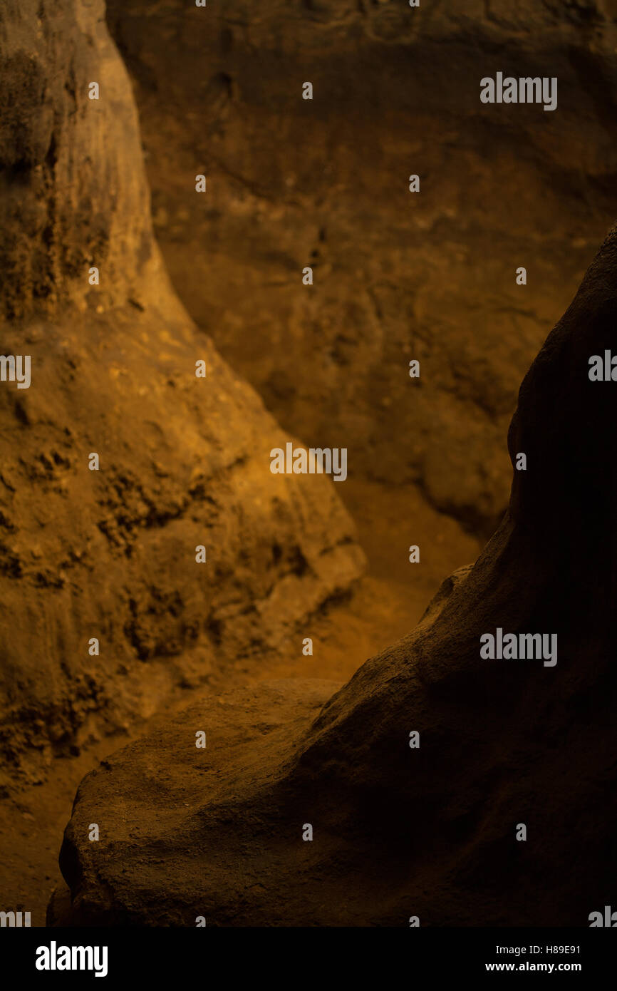 Trail that leads through a dimly lit cave Stock Photo - Alamy