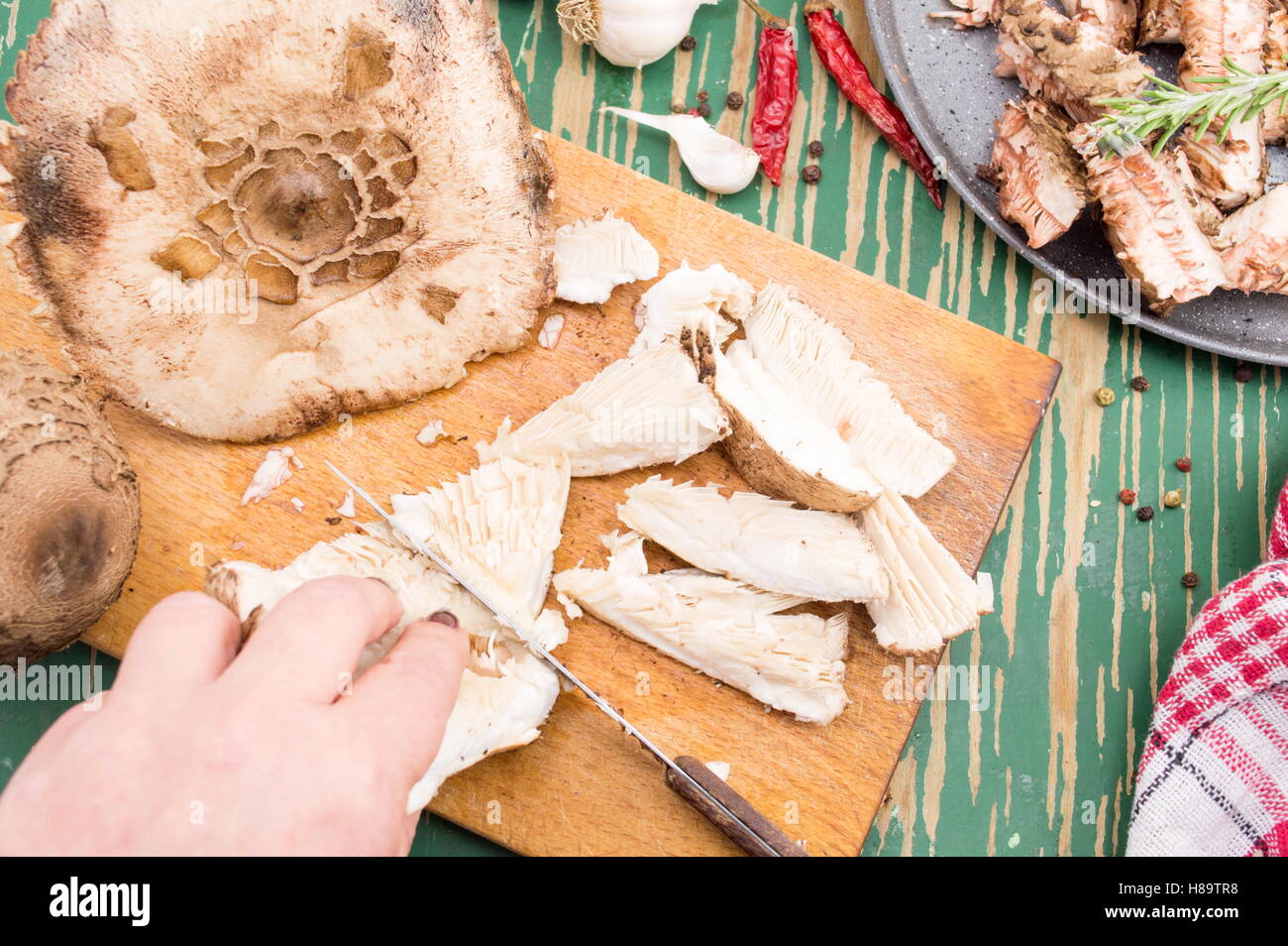 Woman hand cutting parasol mushrooms on a board Stock Photo - Alamy
