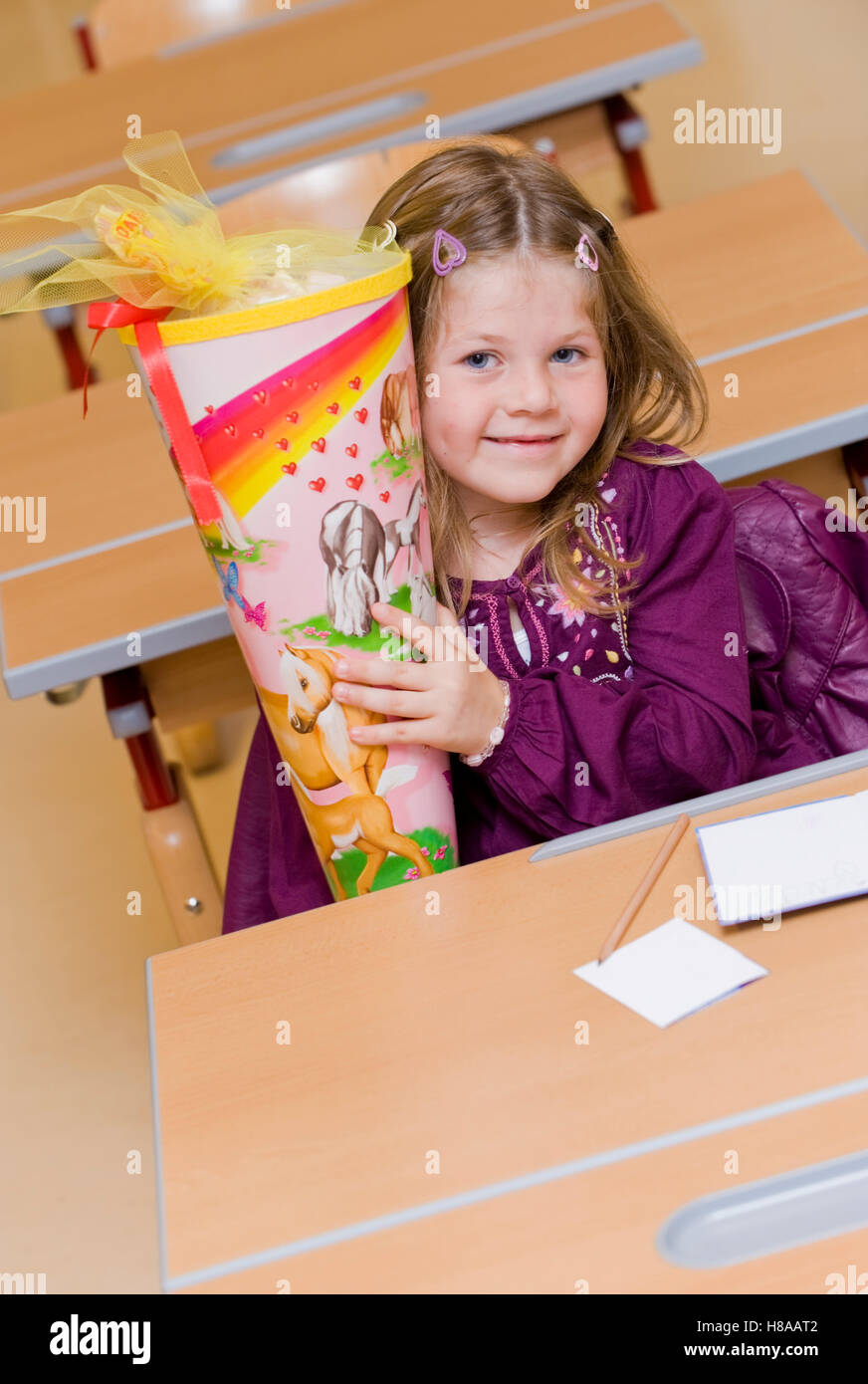 Child starting school, in a classroom, holding a school cone Stock ...
