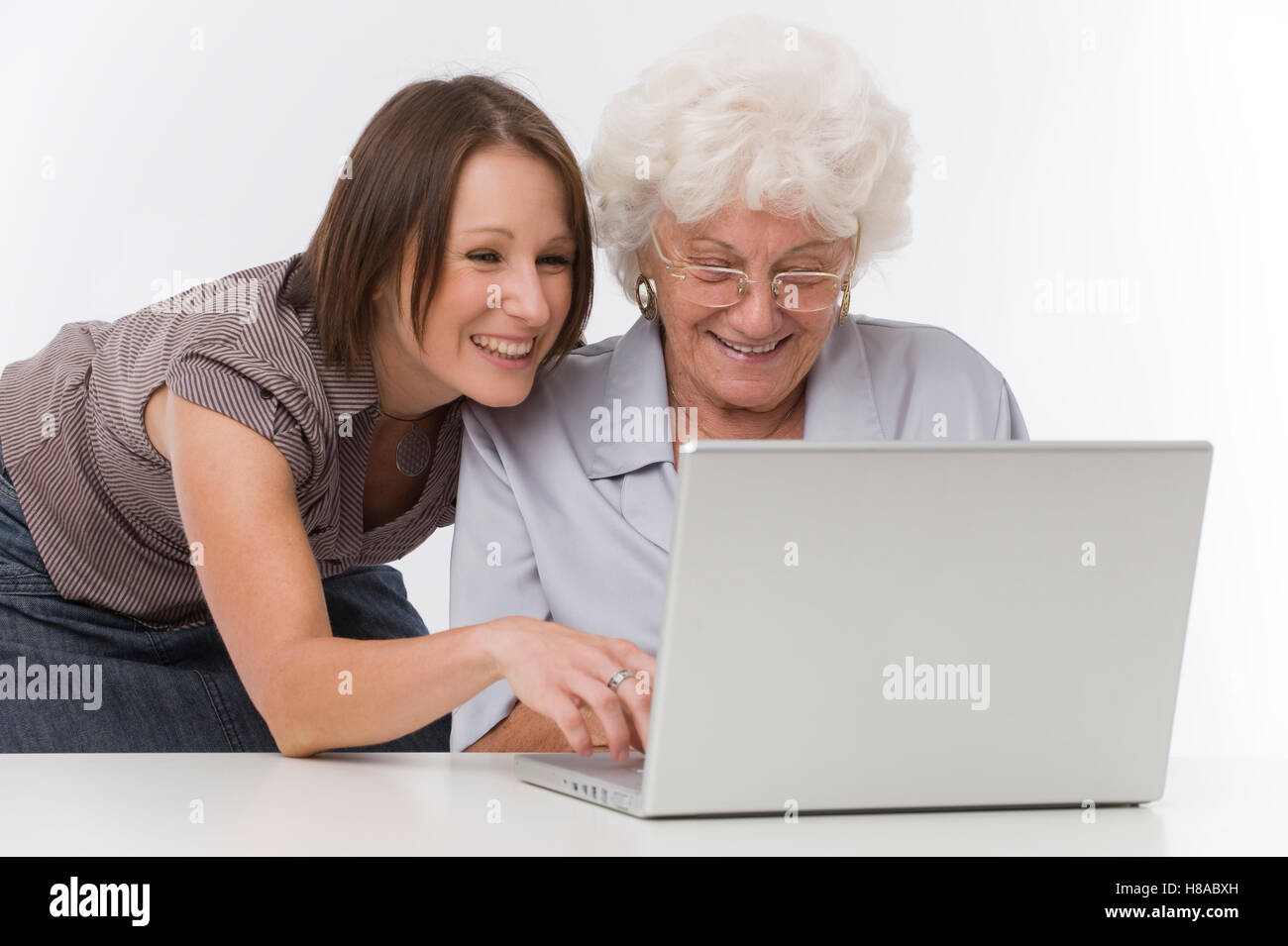 Young woman helping older woman using a laptop Stock Photo - Alamy