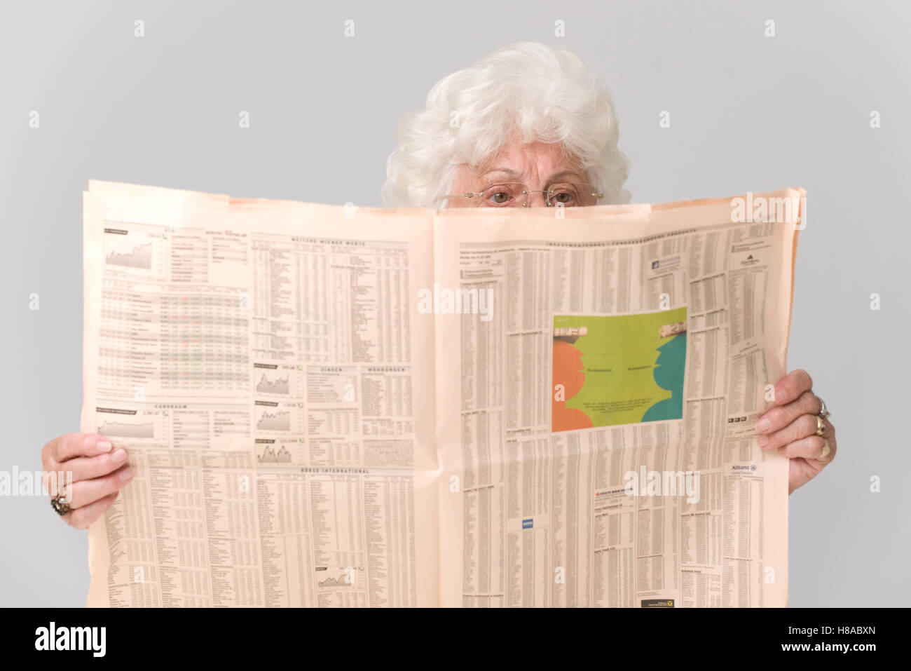 Senior woman reading a newspaper Stock Photo - Alamy