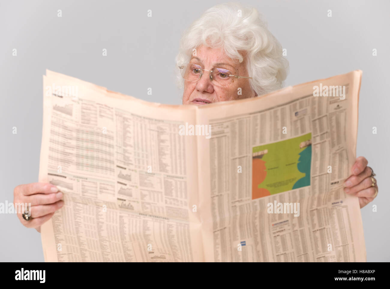 Senior woman reading a newspaper Stock Photo - Alamy