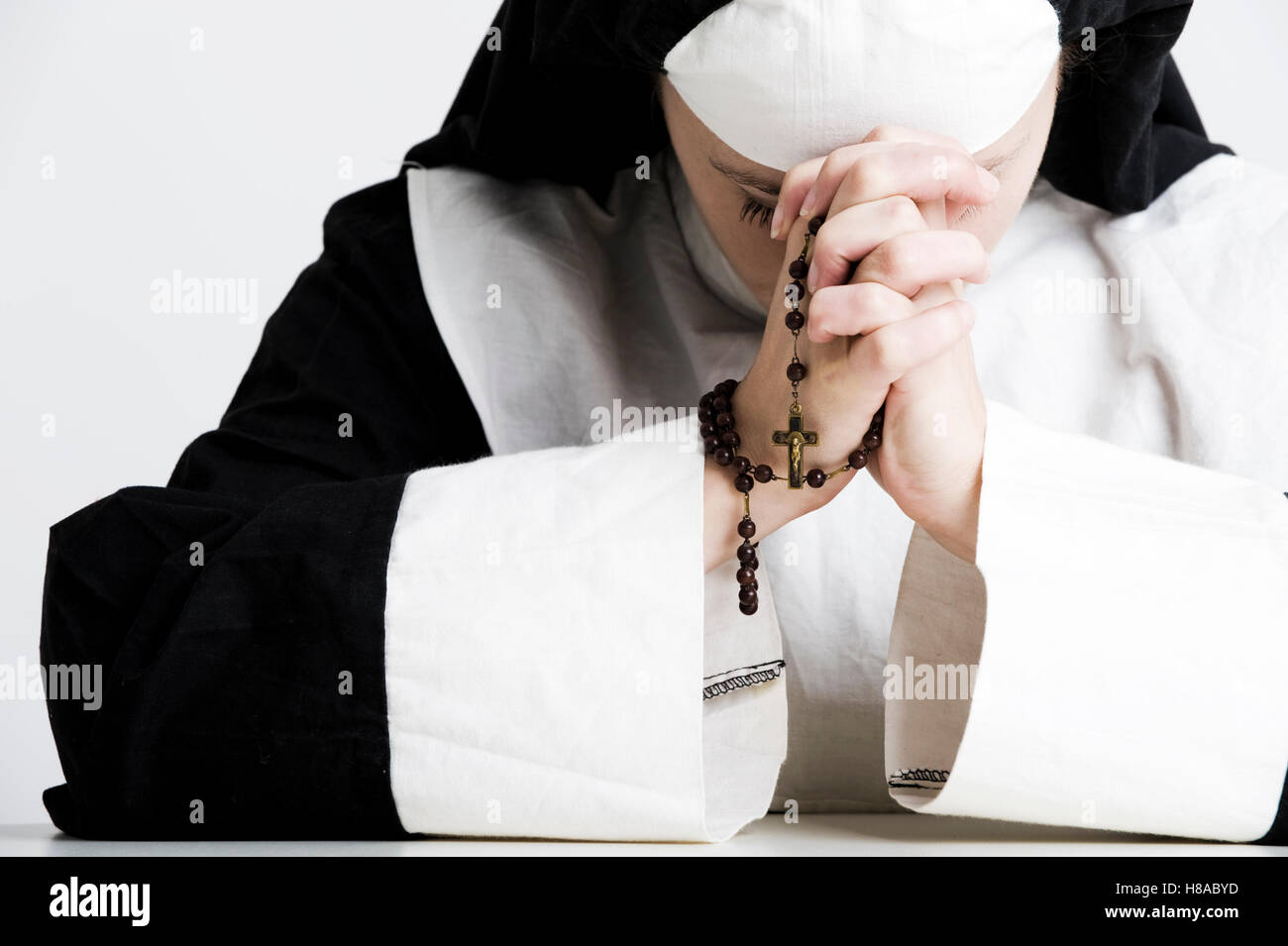 Nun praying the rosary Stock Photo - Alamy