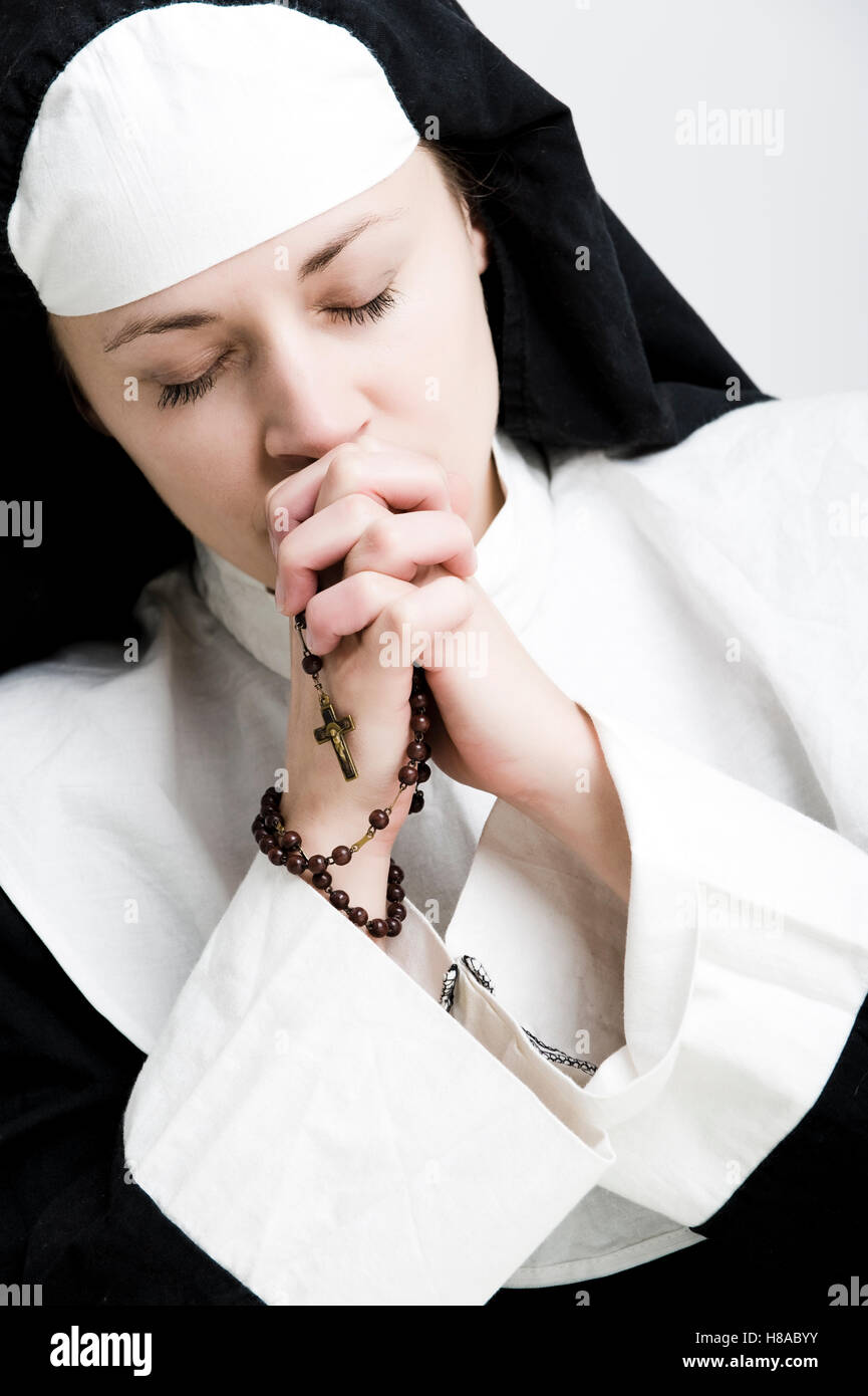 Nun praying the rosary Stock Photo - Alamy