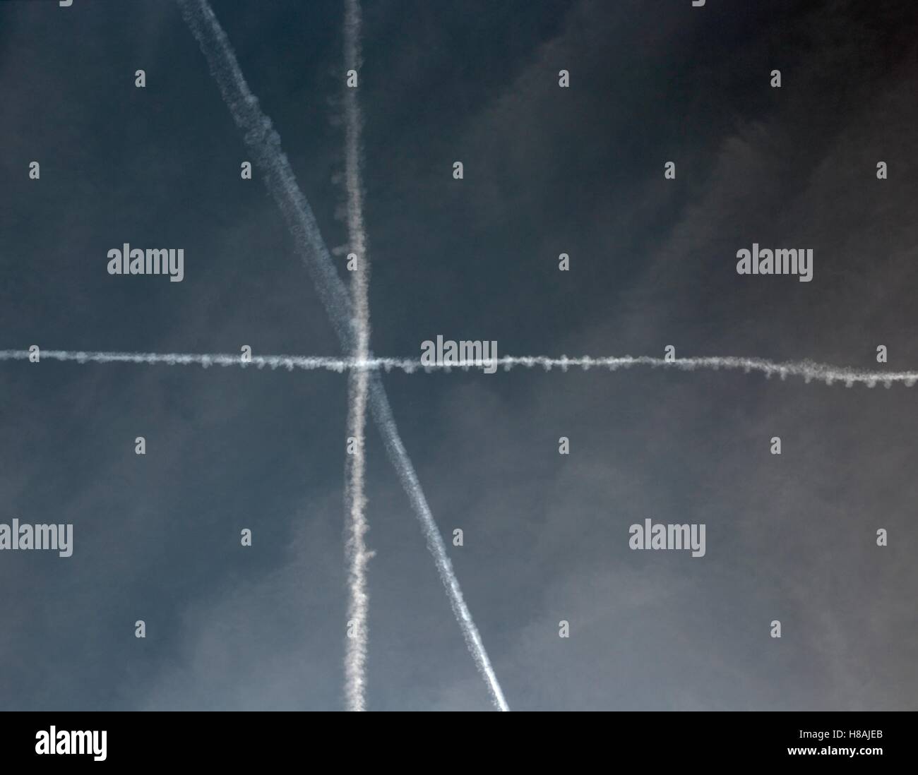 Clouds and plane trails forming shape Stock Photo - Alamy