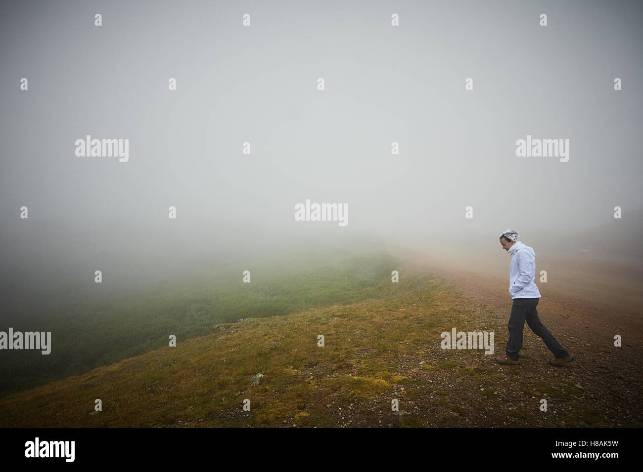 Woman walks through fog in alpine tundra Stock Photo - Alamy