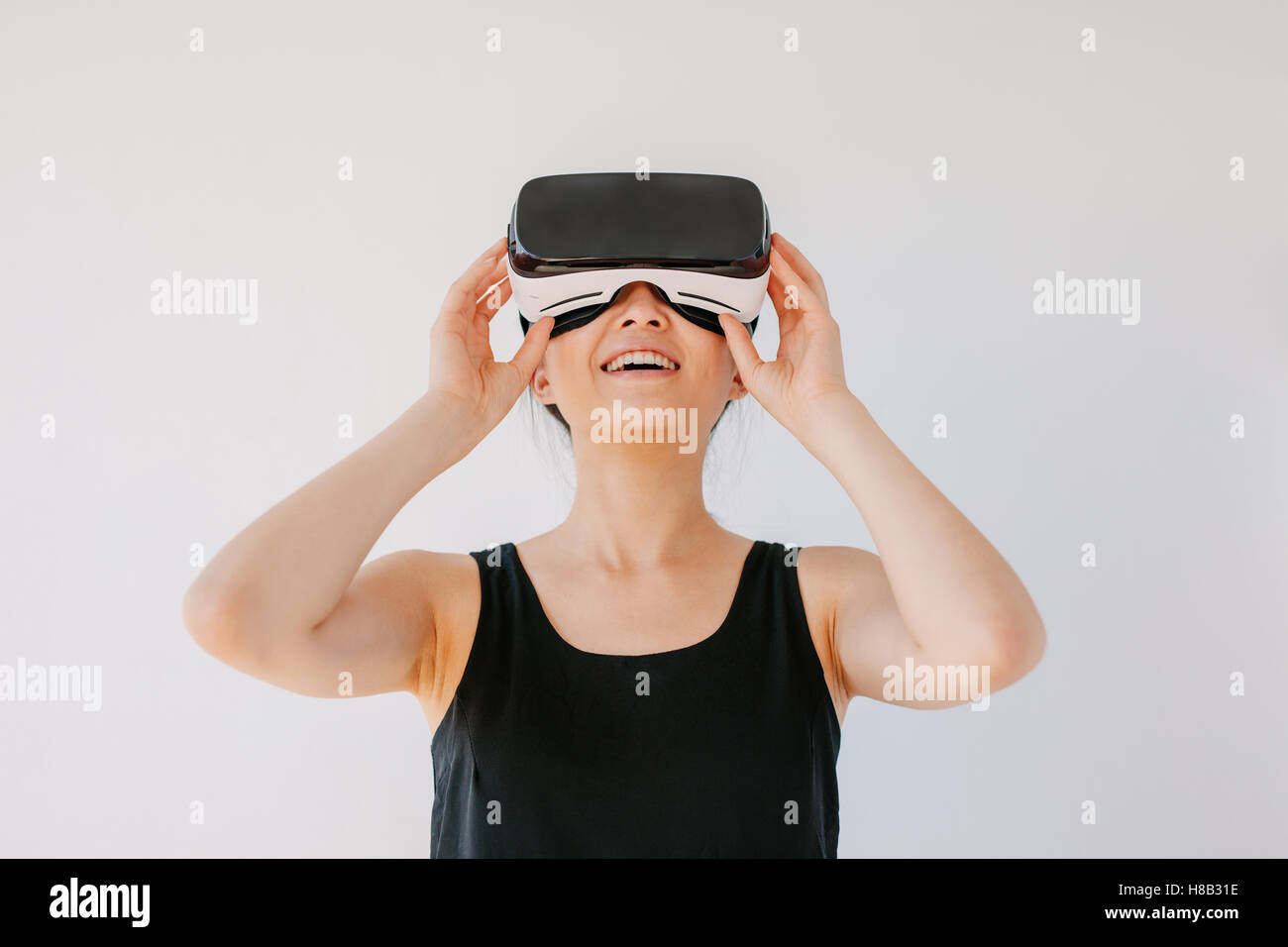 Shot of young woman using the virtual reality headset and smiling ...