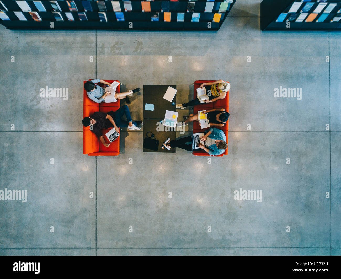 Top view of university students sitting in a library with books and ...