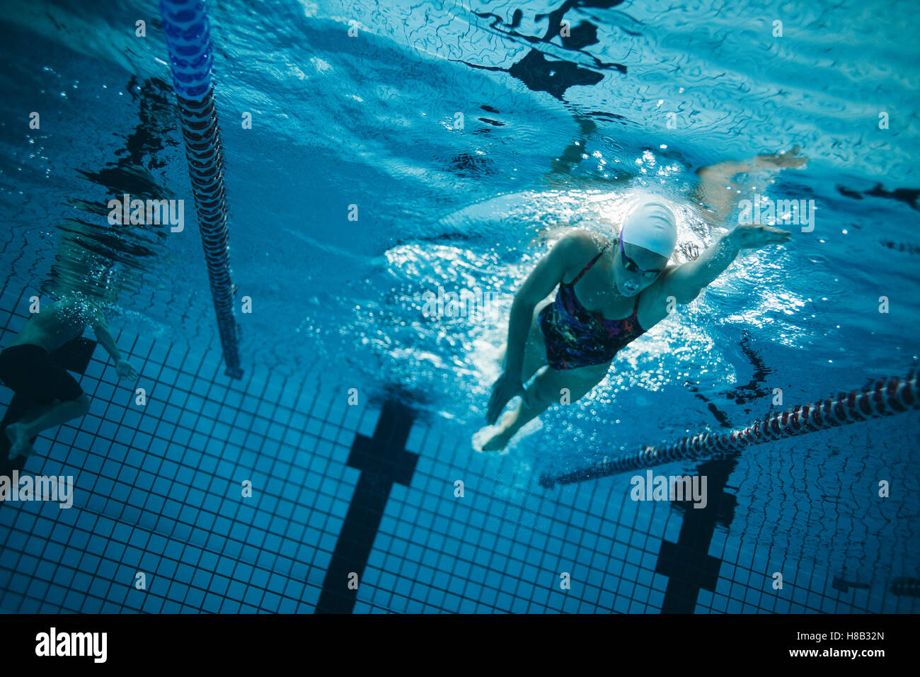 Underwater shot of young female swimmer swimming in pool. Young female ...