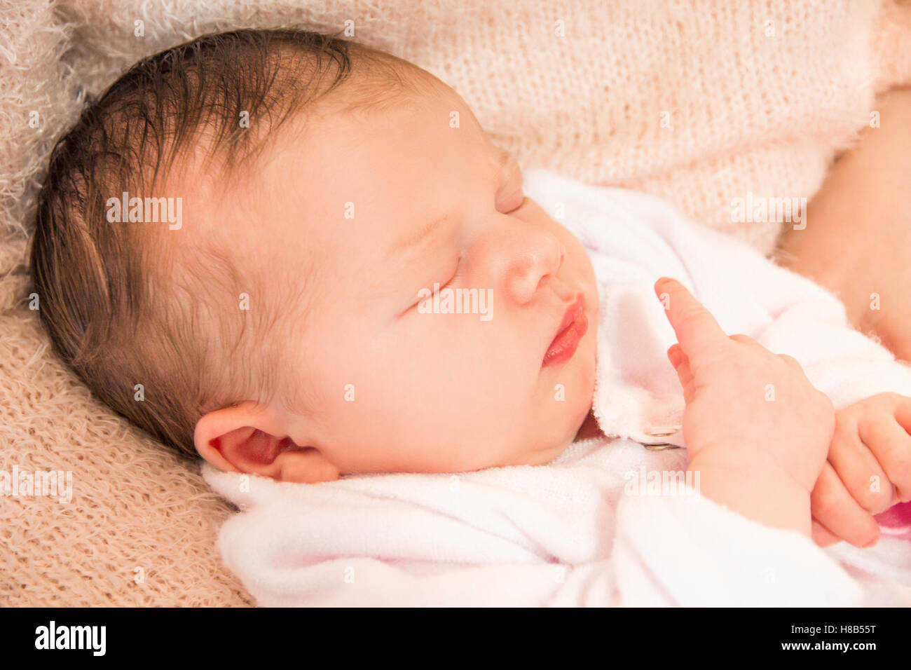 Newborn baby girl sleeping snuggly in mommy's arms Stock Photo - Alamy