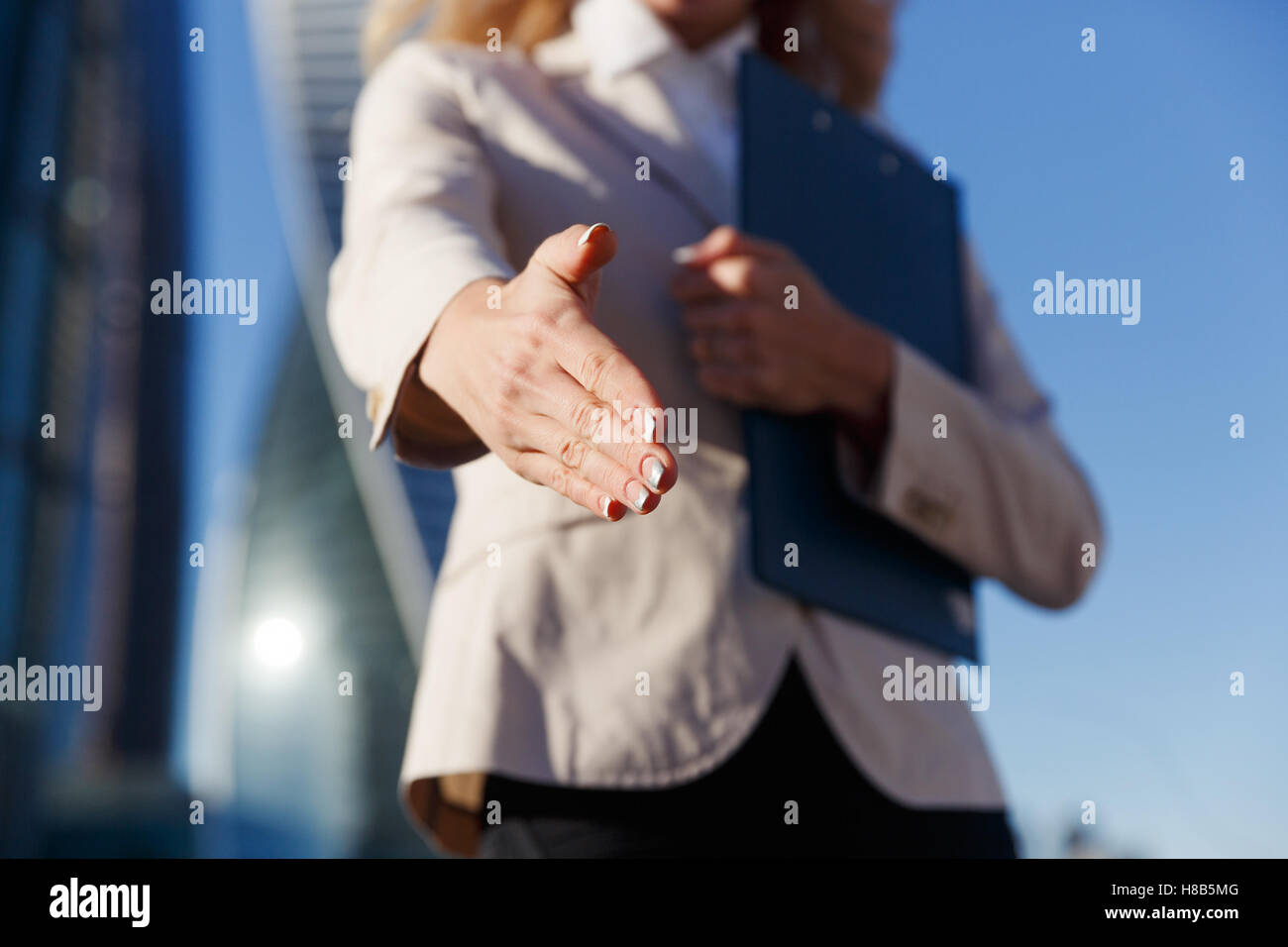 Business woman holding blue folder giving arm extended for handshake ...