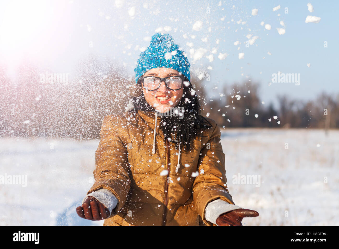 beautiful dark-haired girl hands catching first snow with sunny hotspot ...