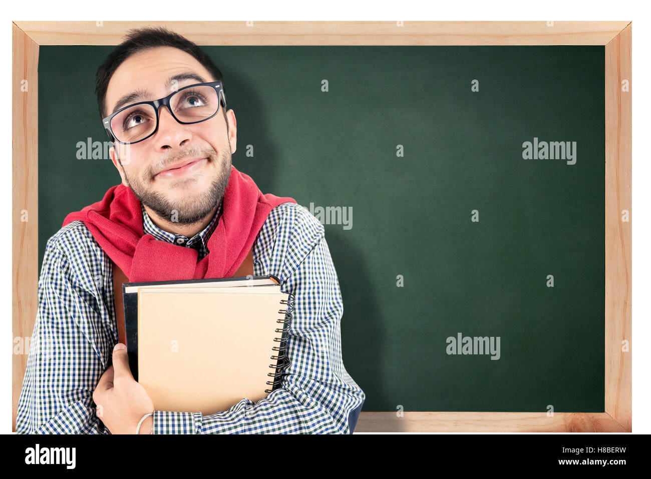 Nerd student posing with books against a chalk board Stock Photo - Alamy