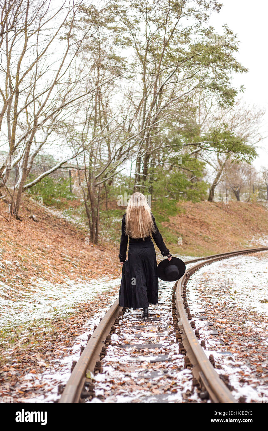 Woman walking on railway tracks Stock Photo - Alamy