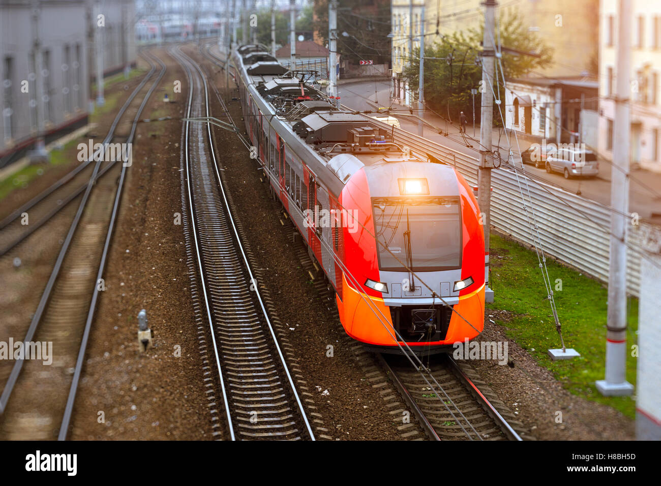 Modern electric locomotive pulling a high-speed train on rails ...