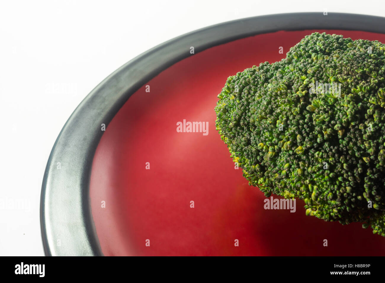 Green Brocolli on Red and Black Plate on White Background Stock Photo ...