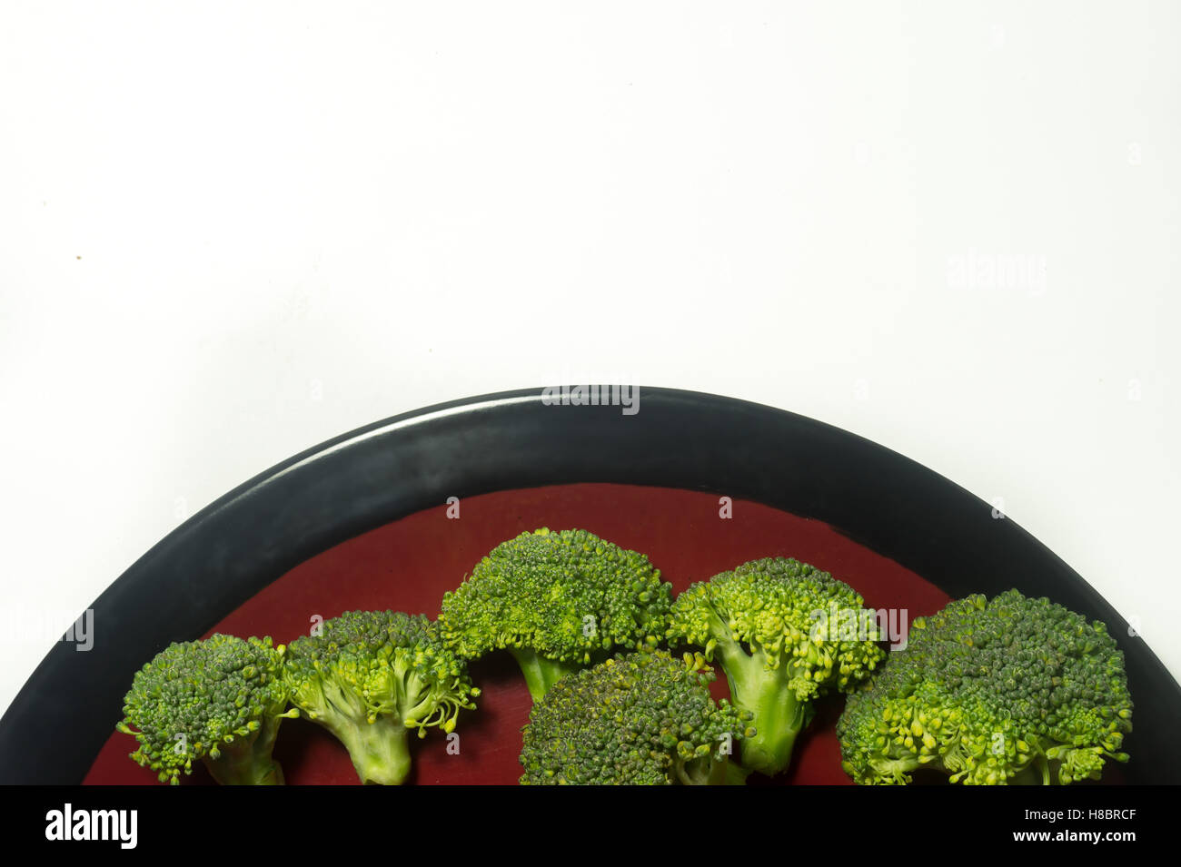 Green Brocolli on Red and Black Plate on White Background Stock Photo ...