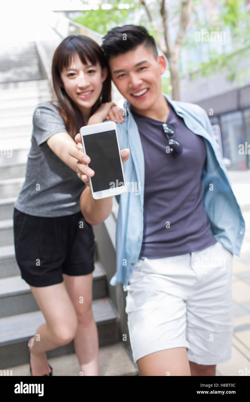 Young Chinese couple showing a smart phone Stock Photo - Alamy