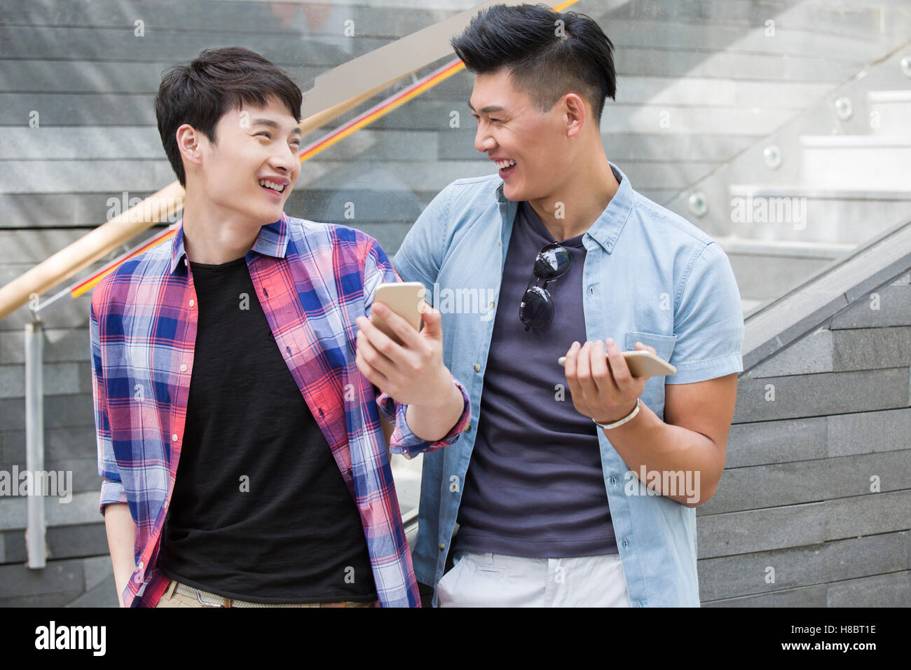 Young Chinese friends holding smart phones Stock Photo - Alamy