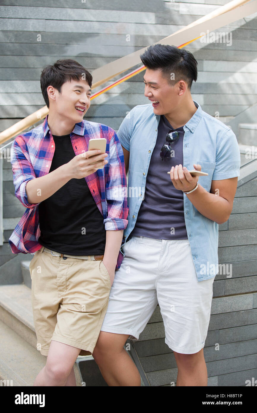 Young Chinese friends holding smart phones Stock Photo - Alamy