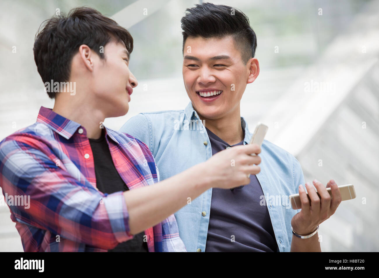 Young Chinese friends holding smart phones Stock Photo - Alamy