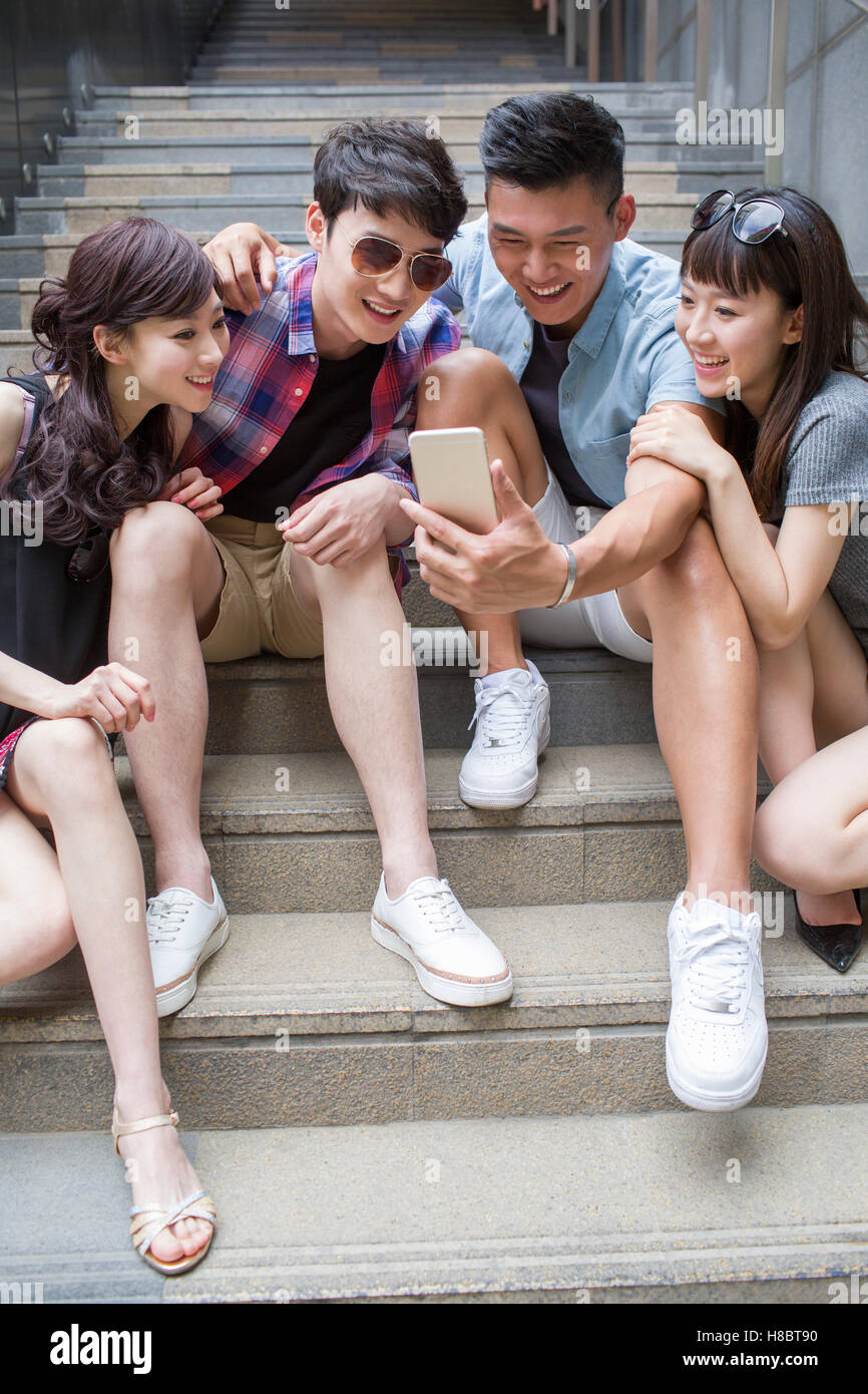 Young Chinese friends looking at a smart phone Stock Photo - Alamy