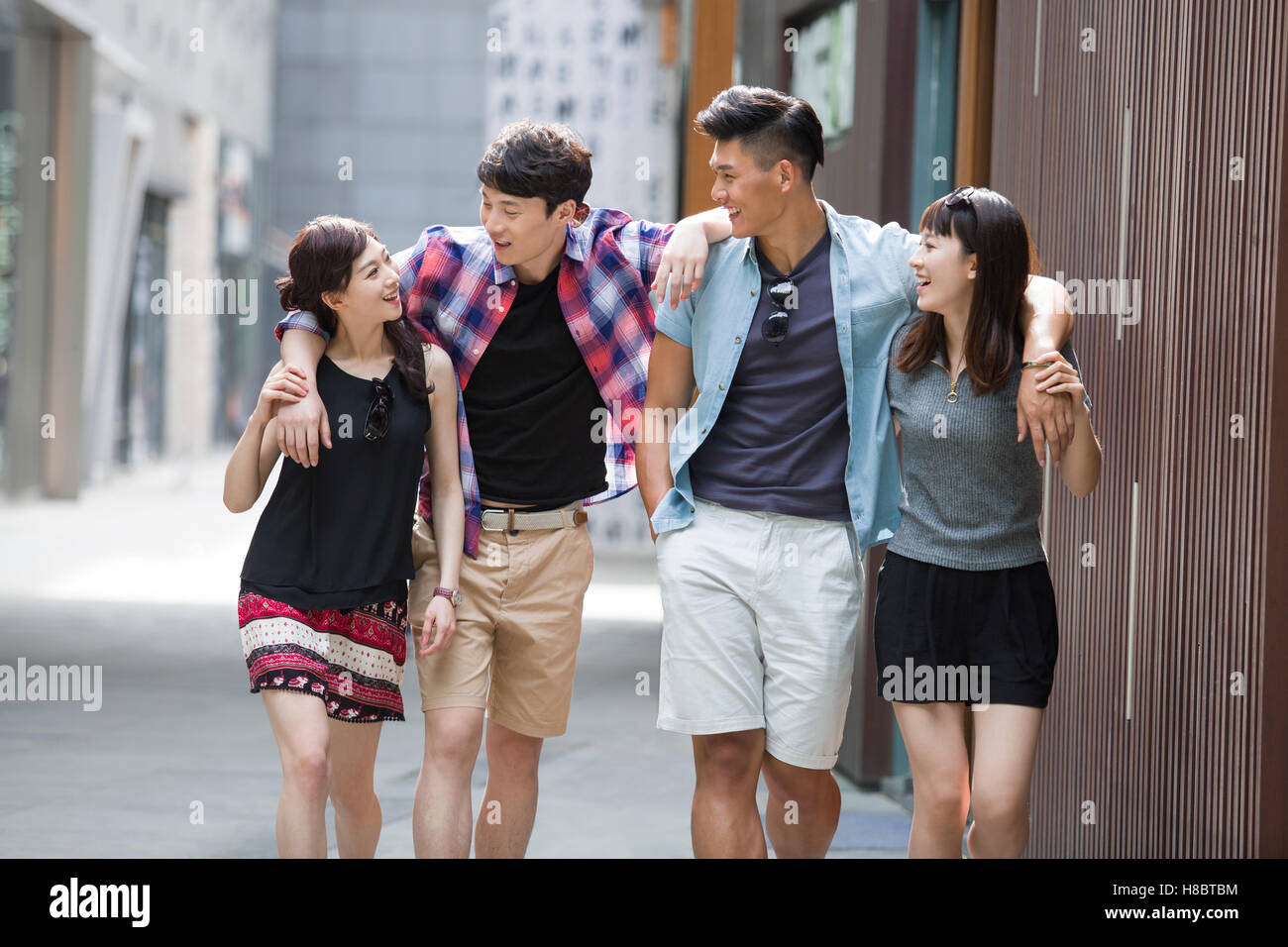 Happy young Chinese friends walking Stock Photo - Alamy