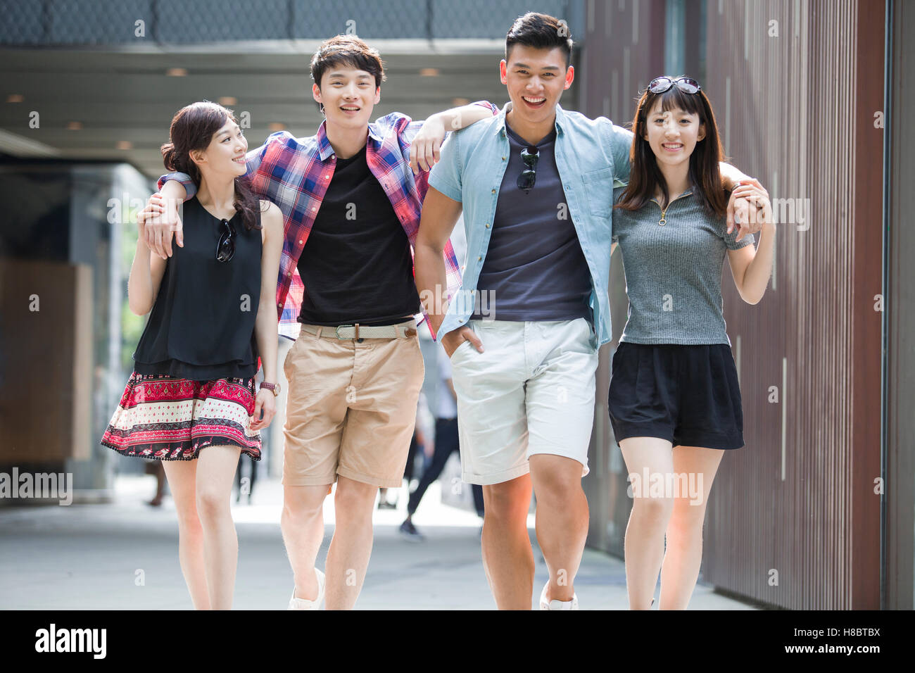 Happy young Chinese friends walking Stock Photo - Alamy