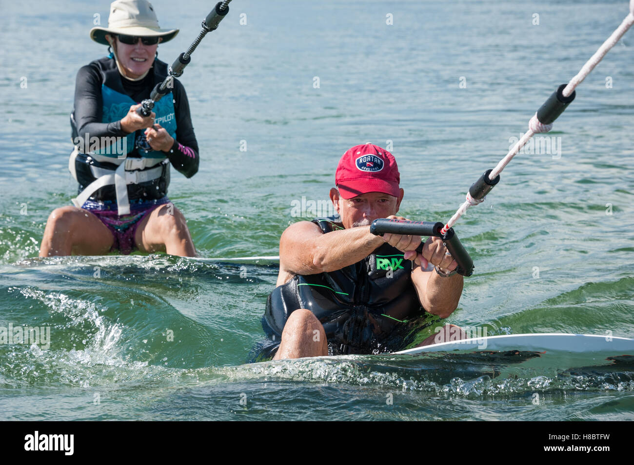 Senior wakesurfers taking off behind a Mastercraft wakesurfing boat on ...
