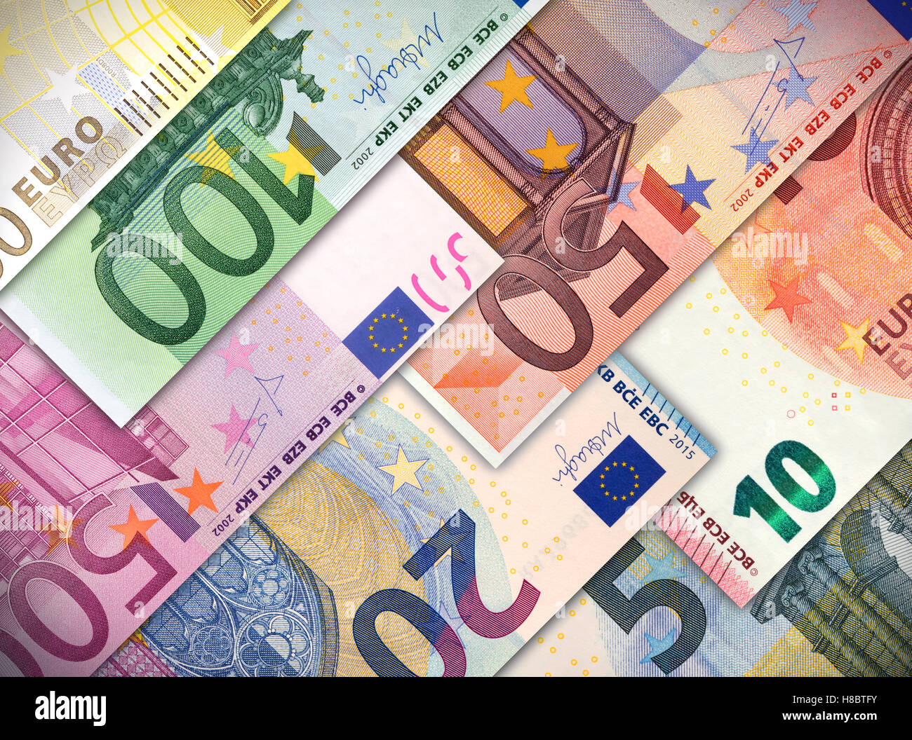 Different money bills stacked over each other forming a money ...