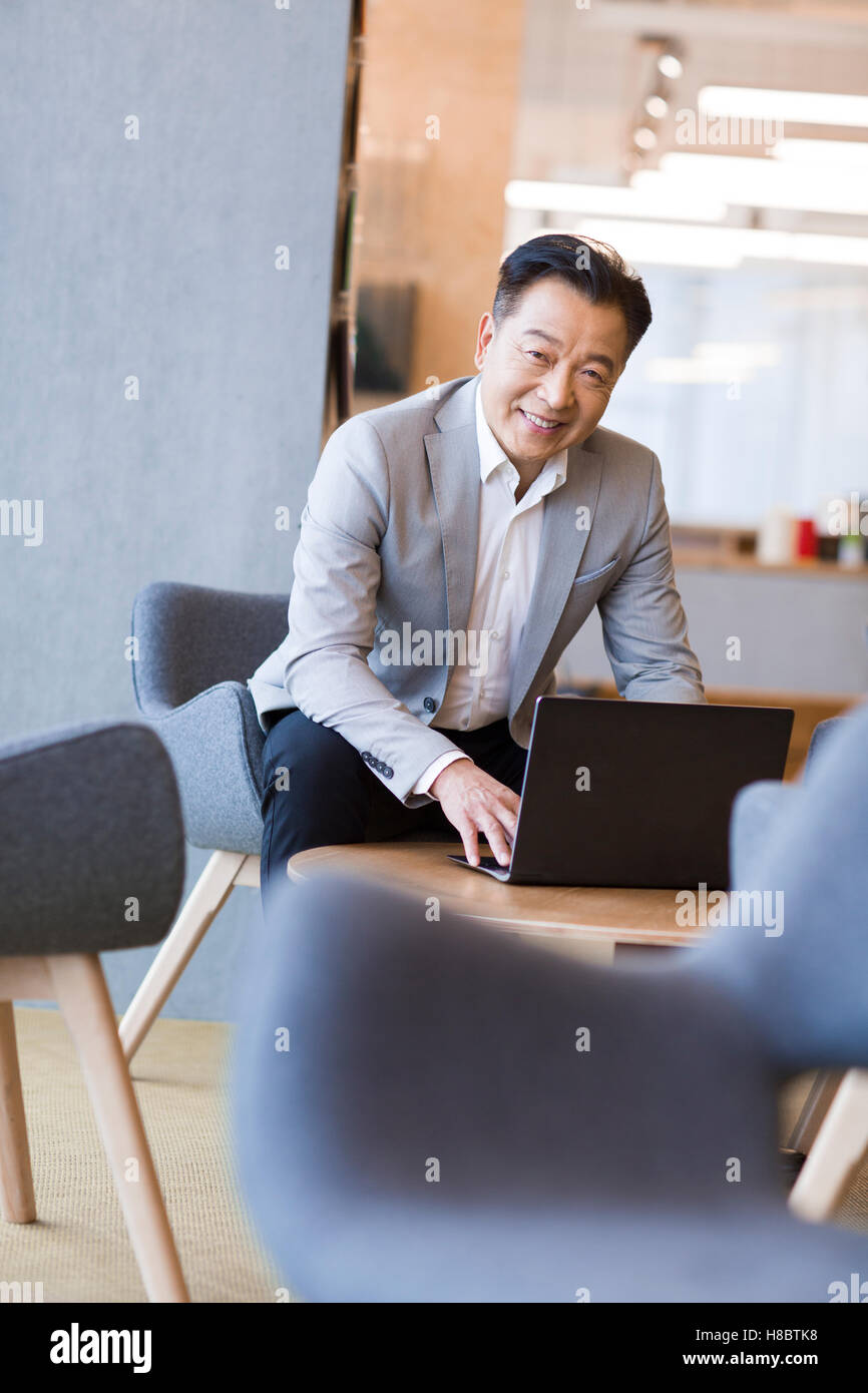 Confident Chinese businessman using laptop Stock Photo - Alamy