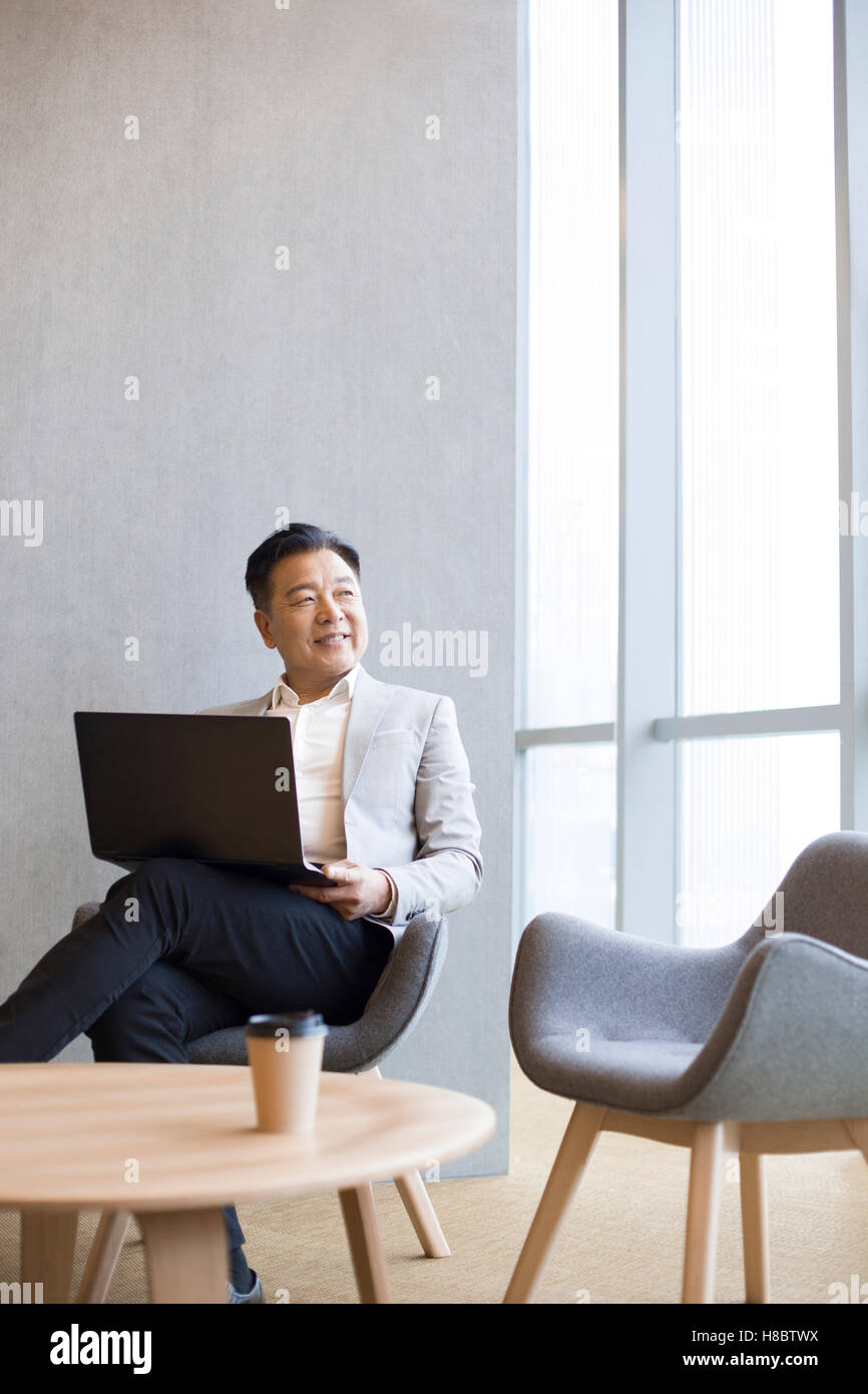 Confident Chinese businessman using laptop Stock Photo - Alamy