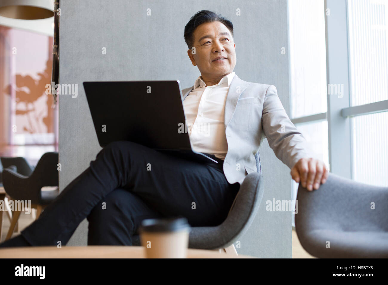 Confident Chinese businessman using laptop Stock Photo - Alamy
