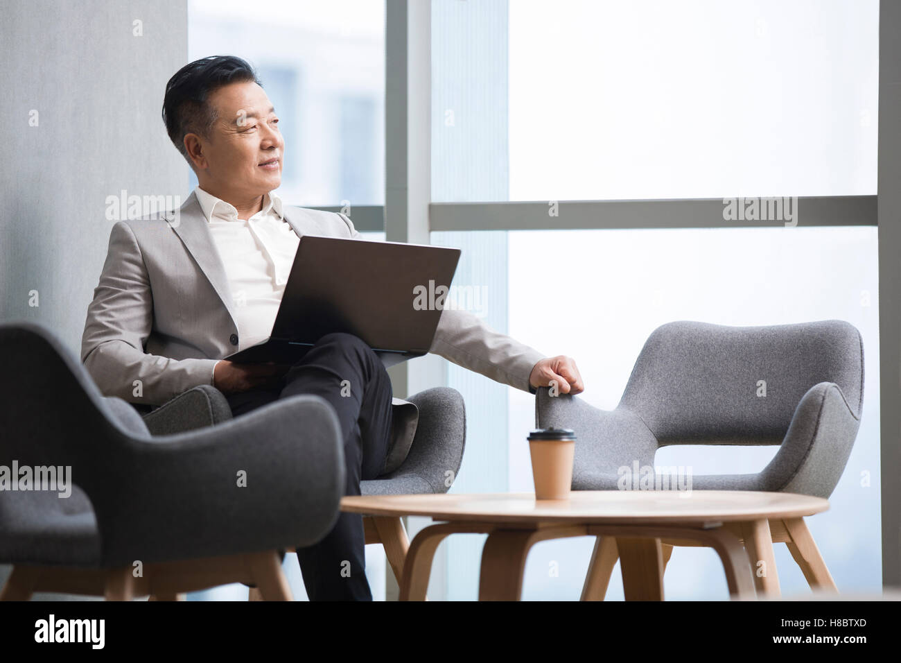 Confident Chinese businessman using laptop Stock Photo - Alamy