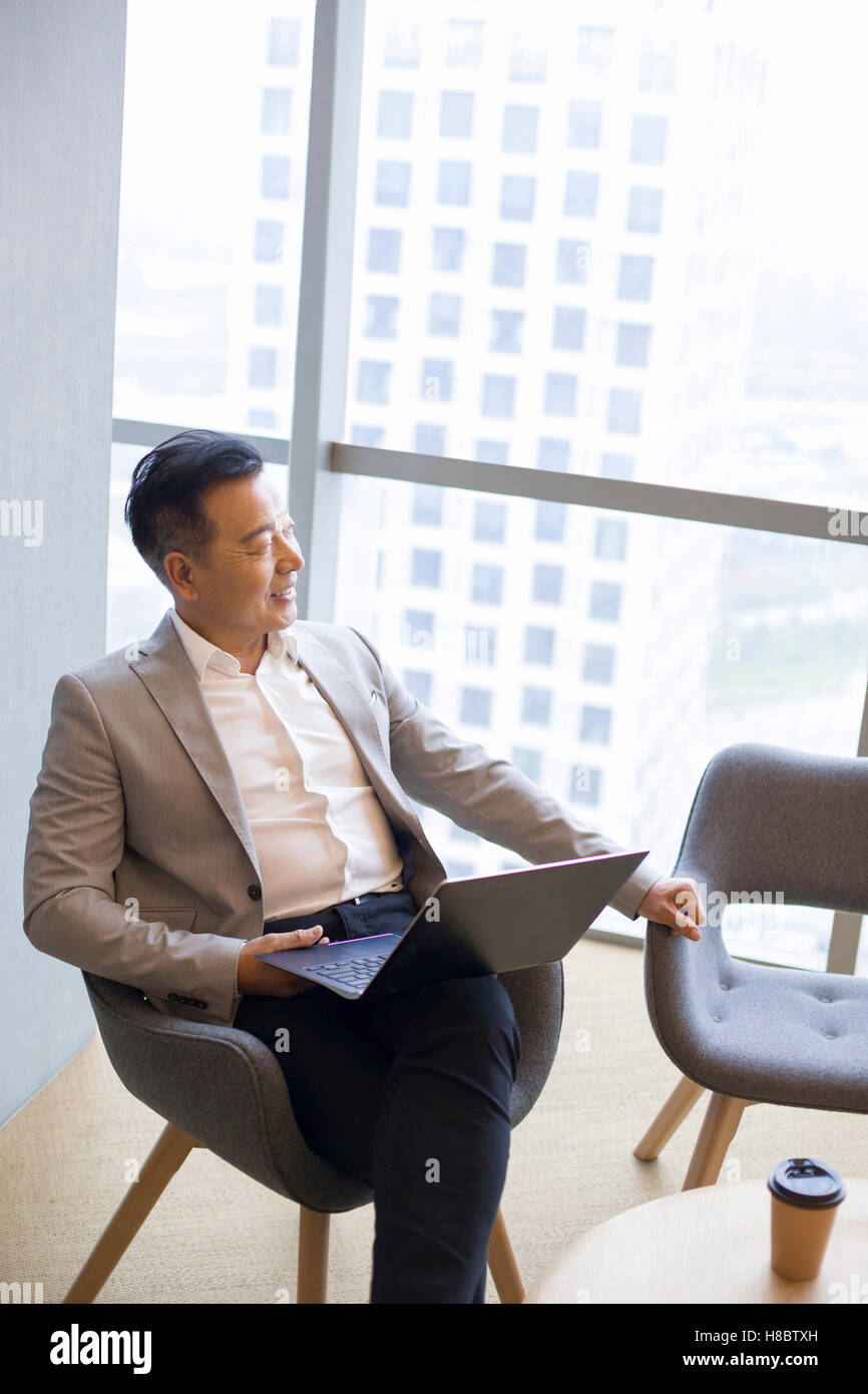 Confident Chinese businessman using laptop Stock Photo - Alamy
