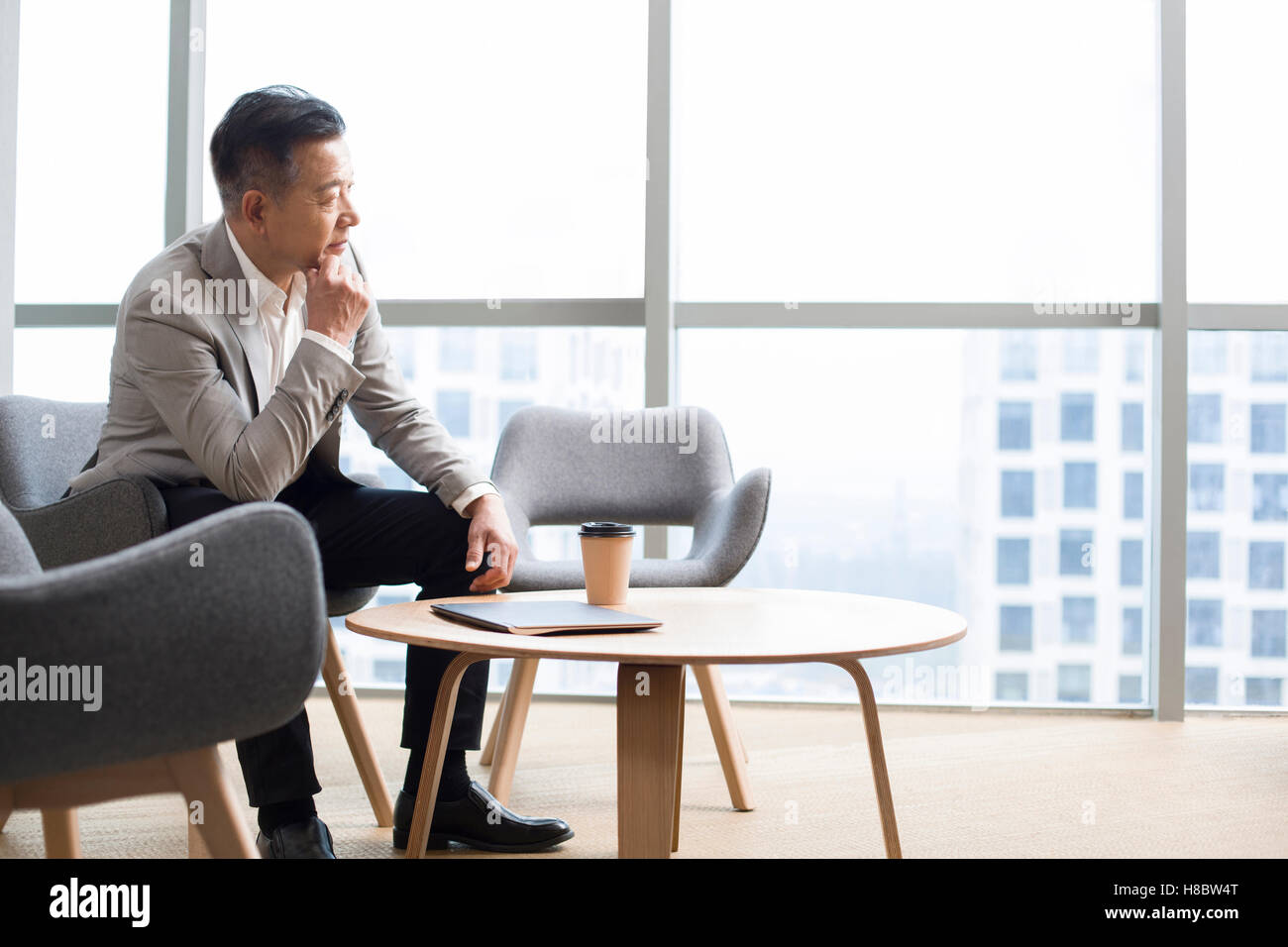 Confident Chinese businessman thinking in office Stock Photo - Alamy