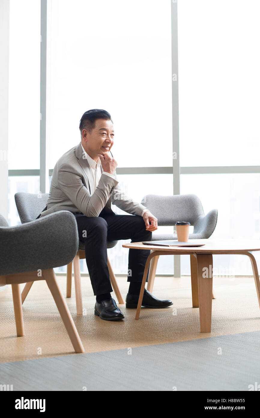 Confident Chinese businessman thinking in office Stock Photo - Alamy