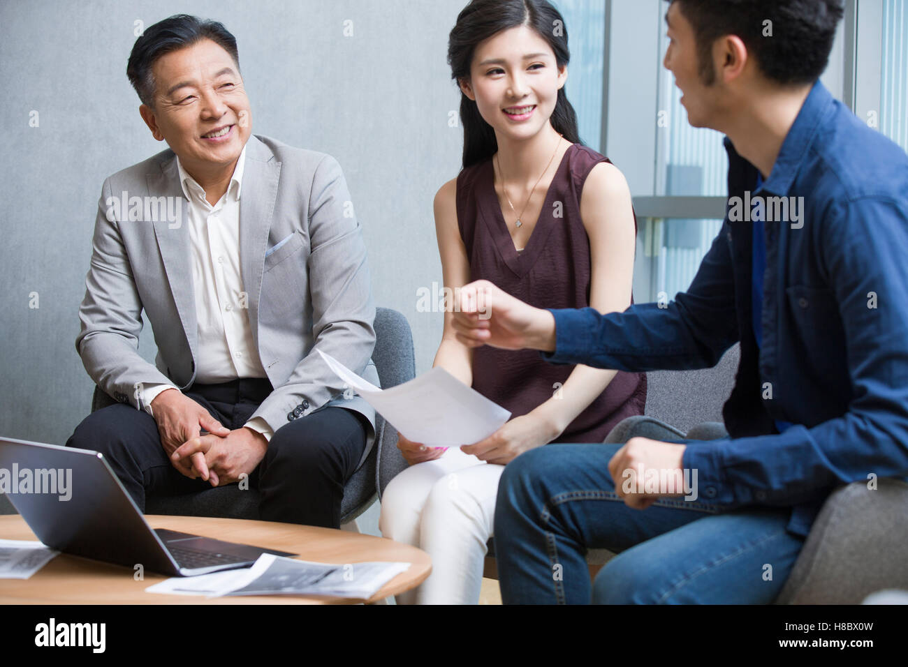 Chinese business people talking in meeting with a laptop Stock Photo ...