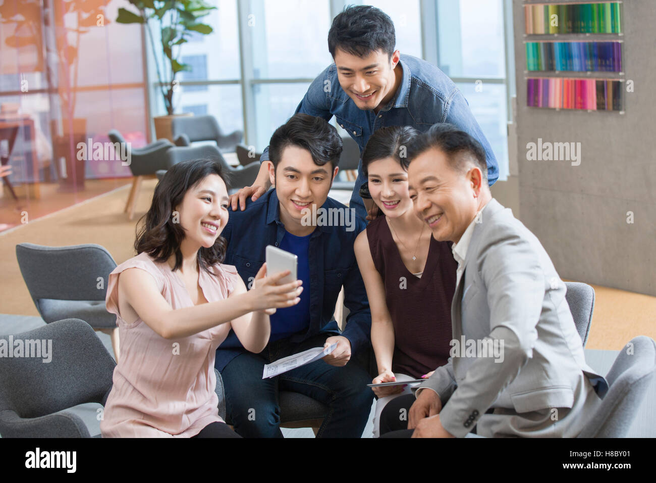 Chinese businesswoman showing smart phone to colleagues Stock Photo - Alamy