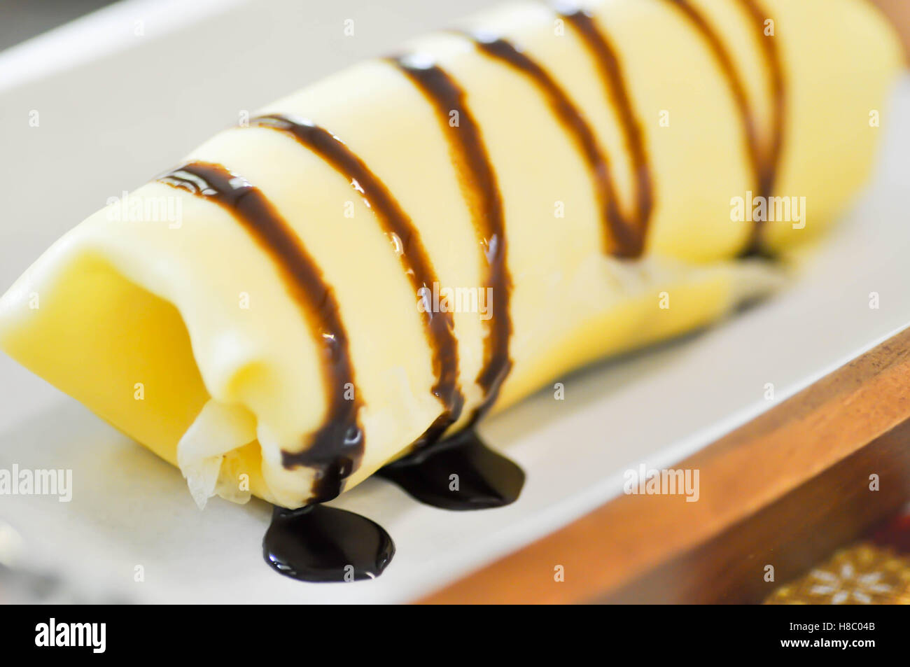 crepe roll with chocolate topping dish Stock Photo - Alamy