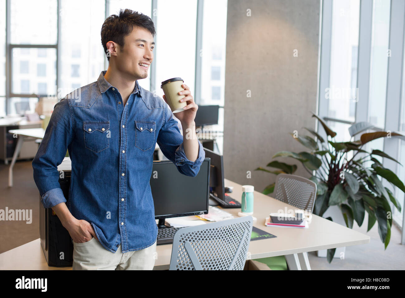 Young Chinese man taking a coffee break Stock Photo - Alamy