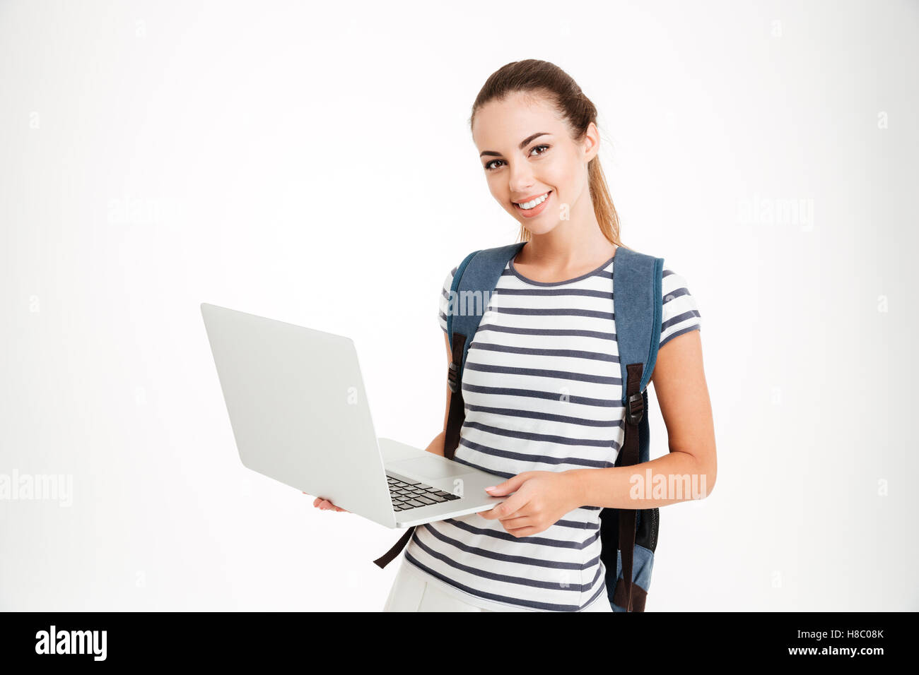 Happy cute student girl with backpack standing and holding laptop ...